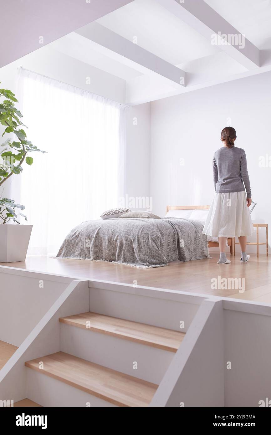 Woman walking with simple bedroom on step floor Stock Photo - Alamy