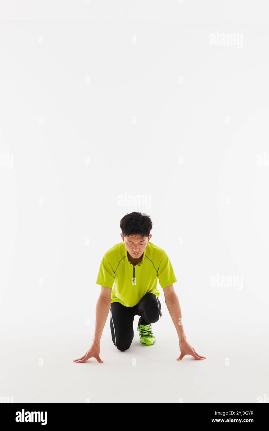 Male track and field athlete taking the starting position Stock Photo ...
