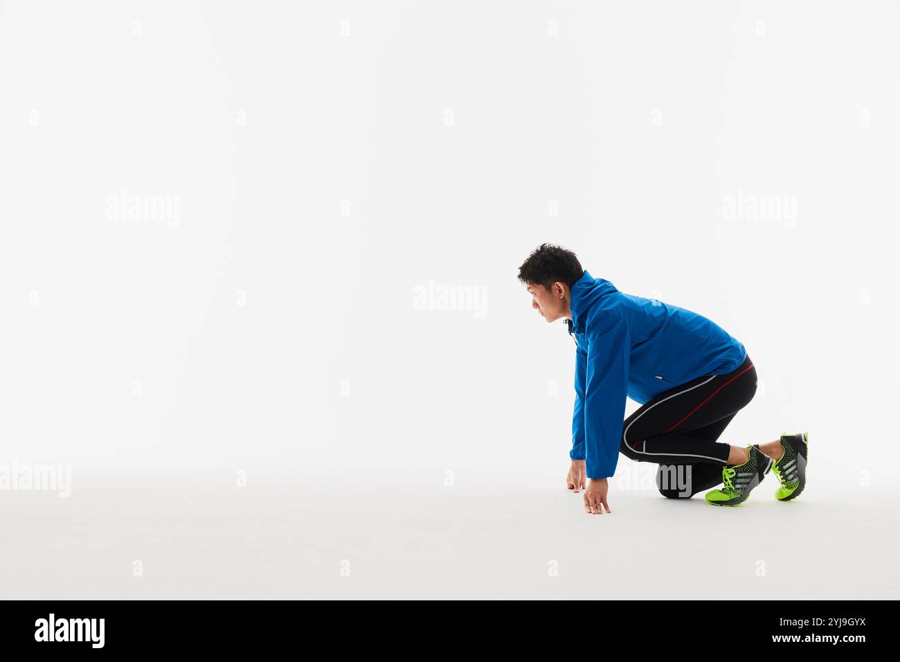 Male track and field athlete taking the starting position Stock Photo ...