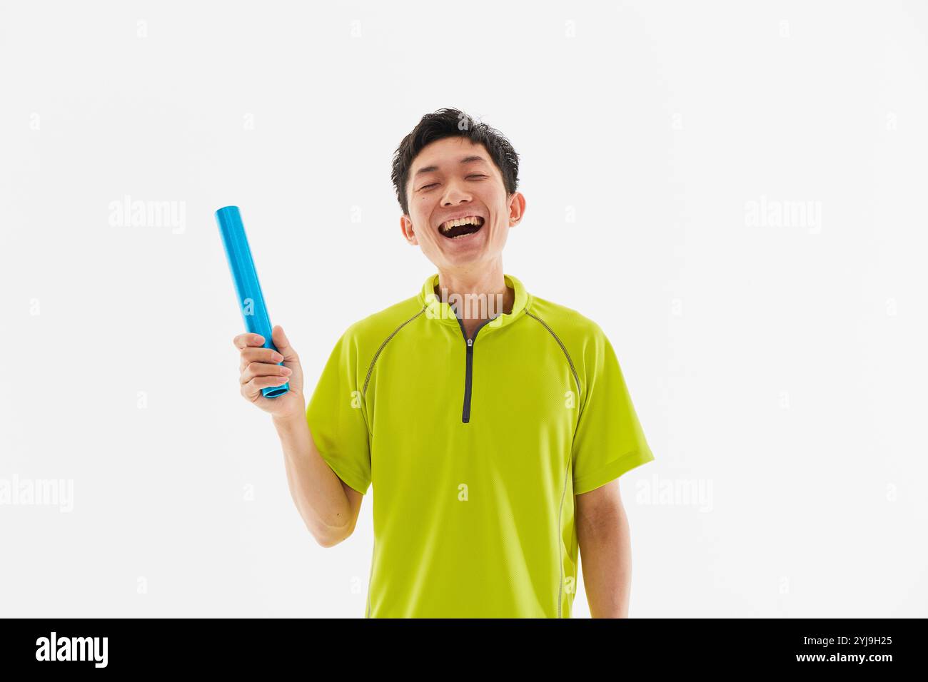 A male athlete smiles as he holds the relay baton Stock Photo - Alamy