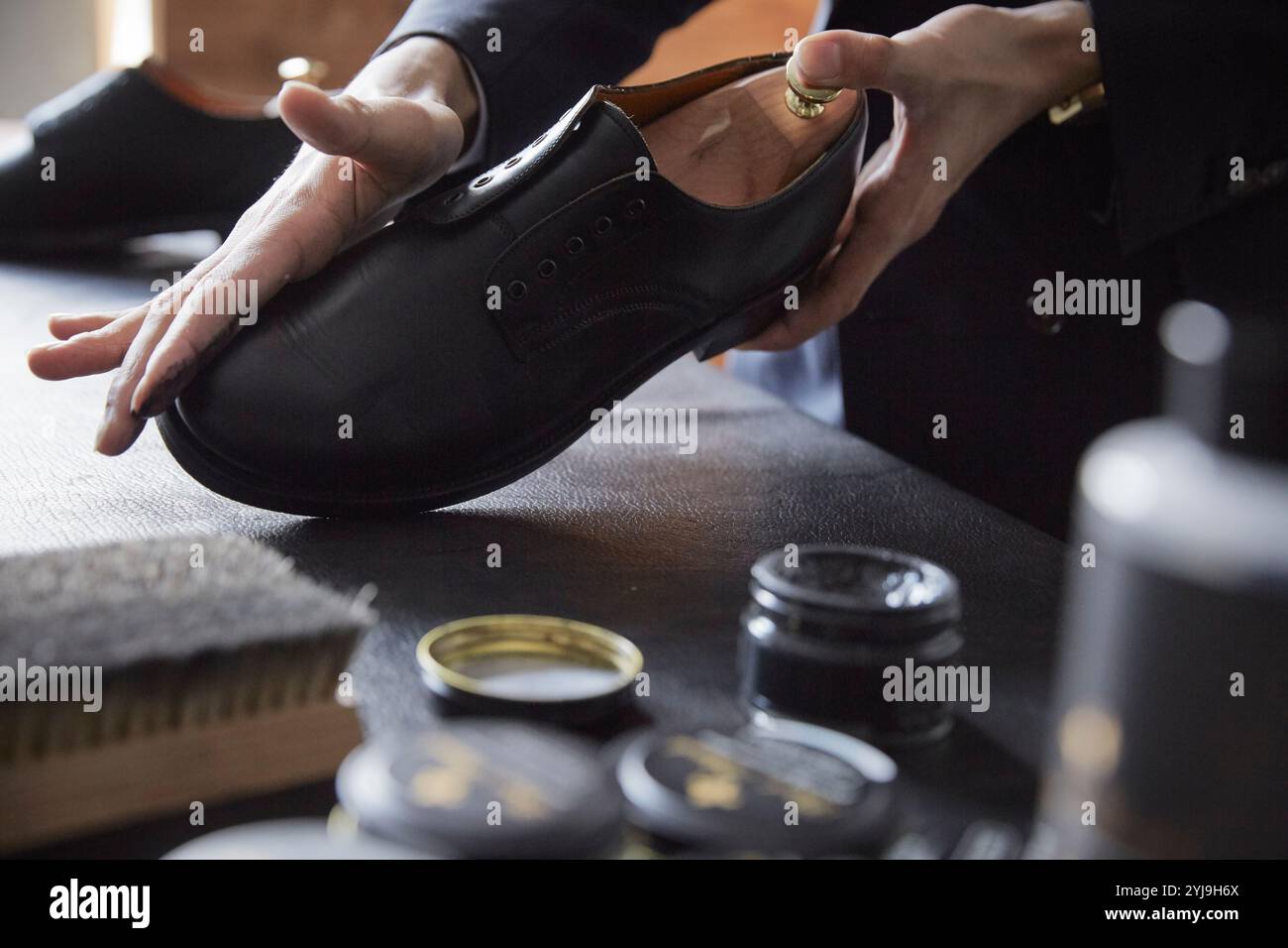 Shoeshiner applying cream to shoes with fingers Stock Photo - Alamy