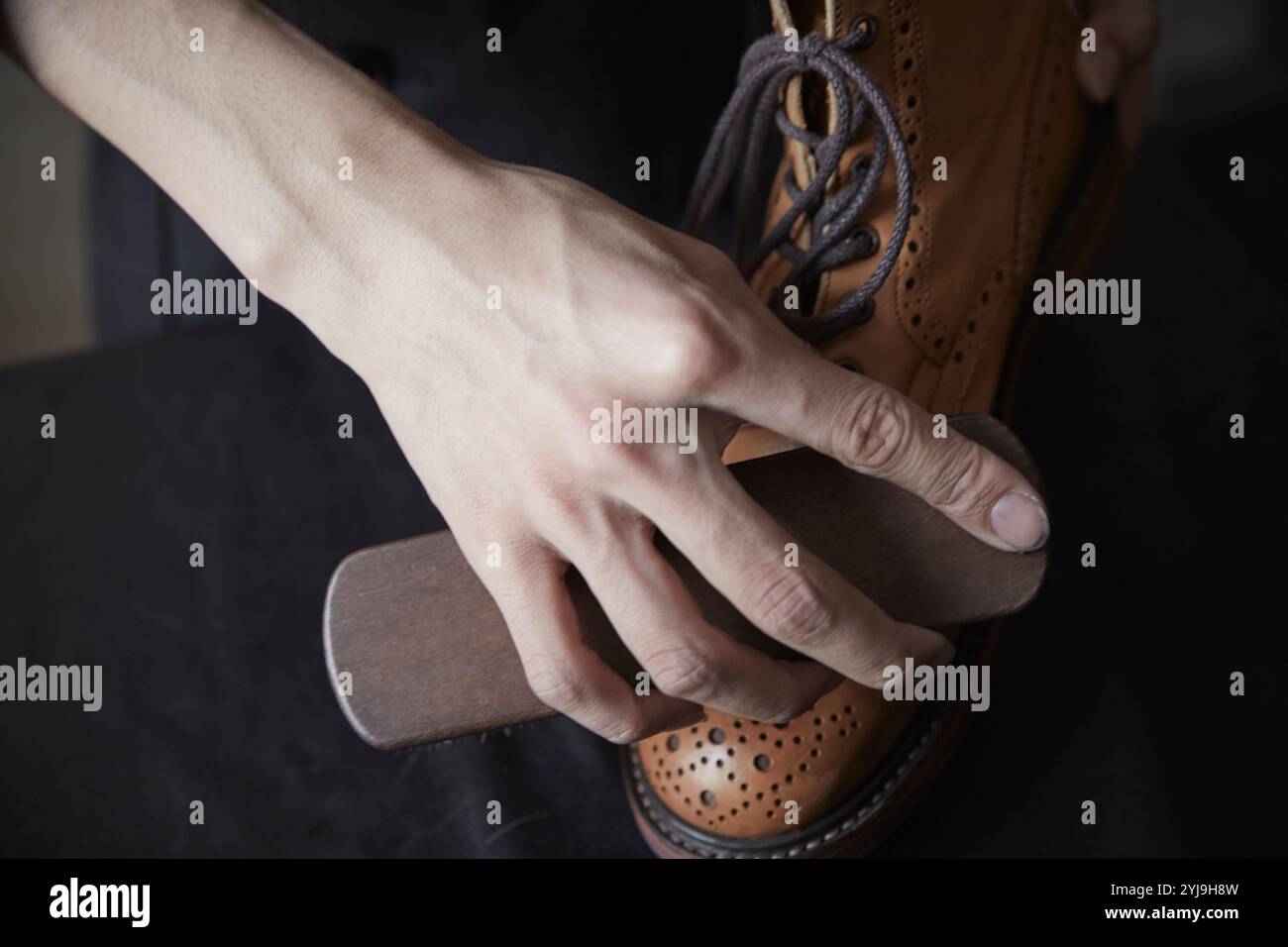 Shoemaker dusting boots with brush Stock Photo - Alamy