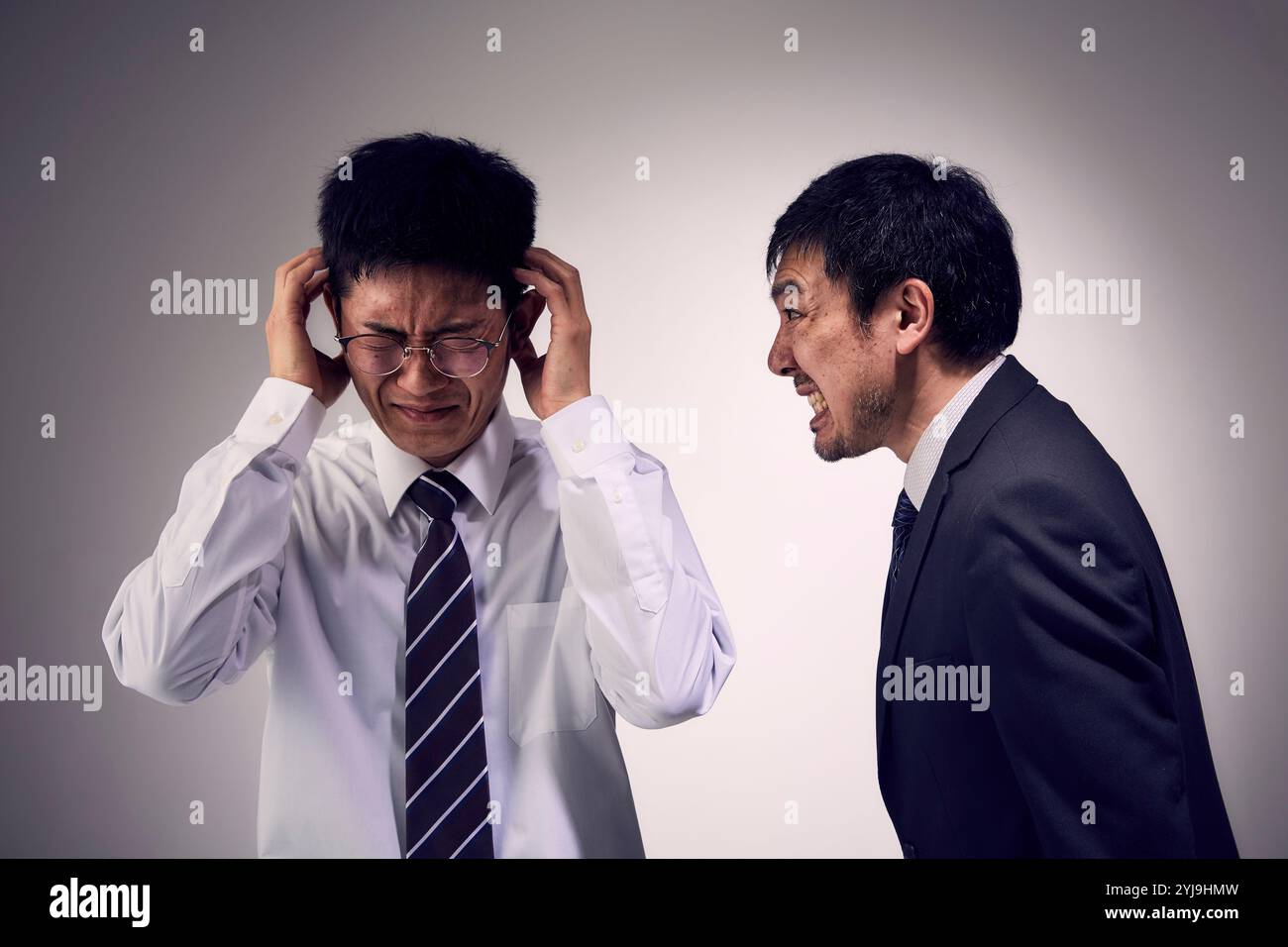 Male employee holding his head after a loud sermon Stock Photo - Alamy