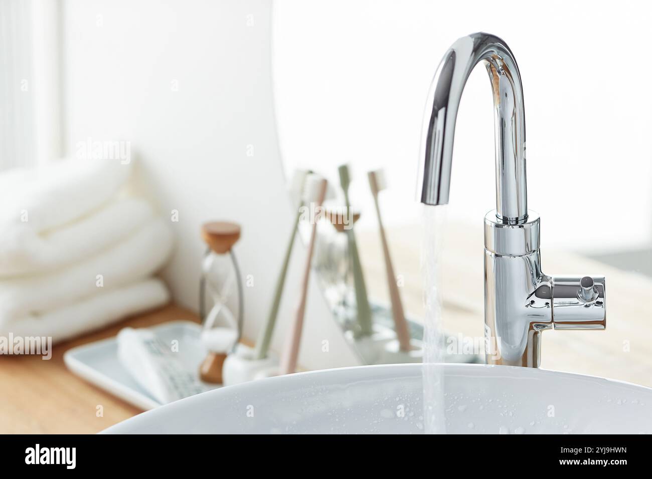 Clean washbasin with water running from the tap Stock Photo - Alamy