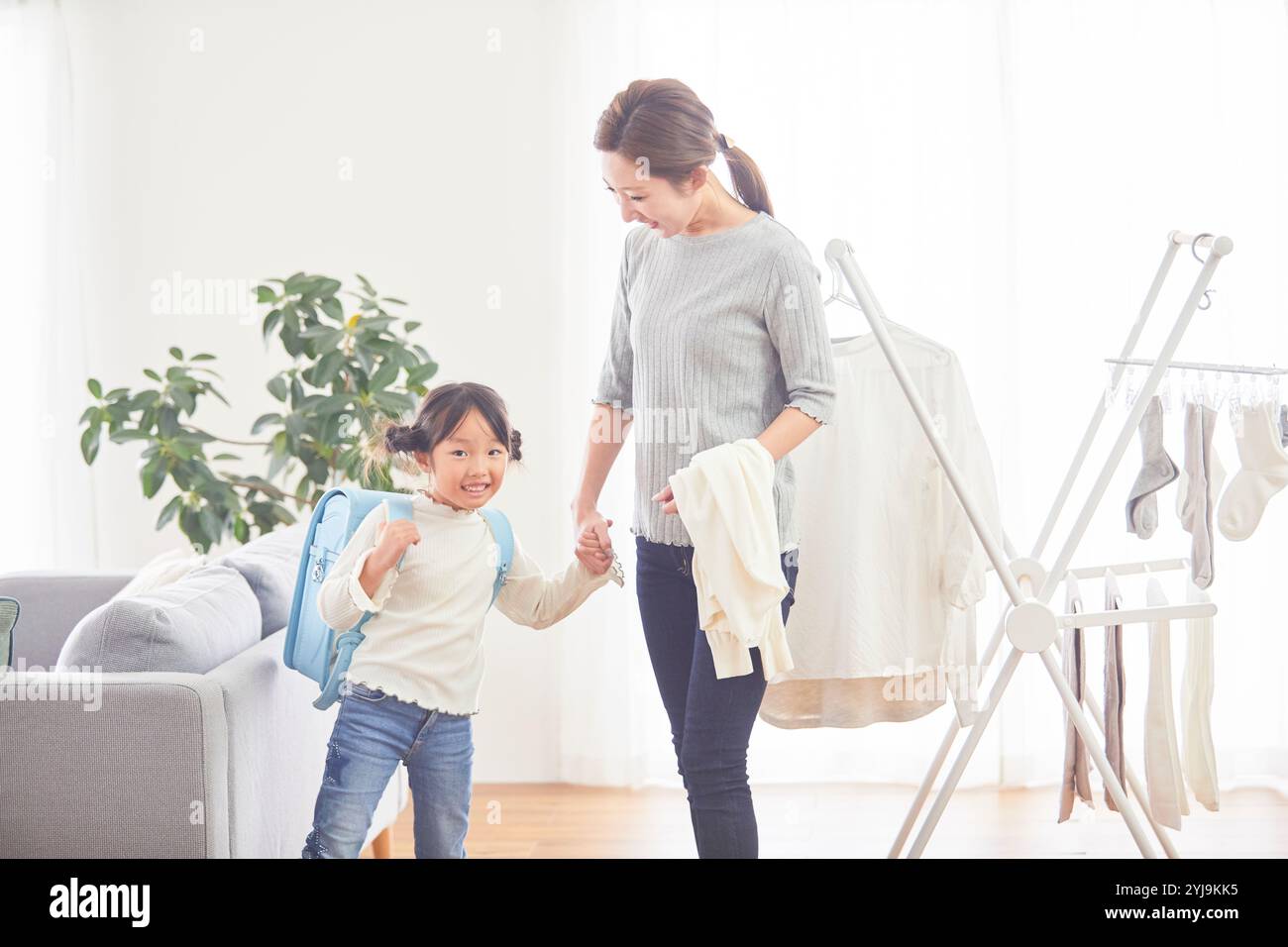 Child and mother getting ready for school in living room Stock Photo ...