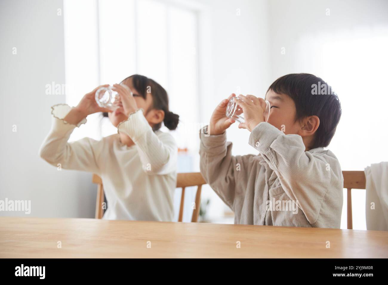 Two children drinking from a cup Stock Photo - Alamy