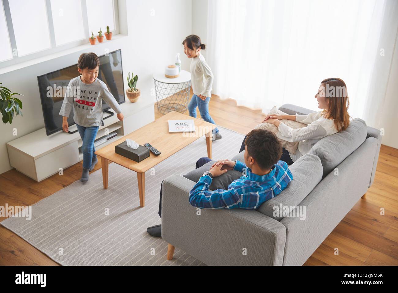 Family enjoying themselves in the living room Stock Photo - Alamy