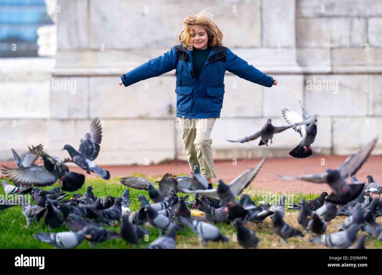 Happy child chasing birds on autumn day. Child run for pigeons ...