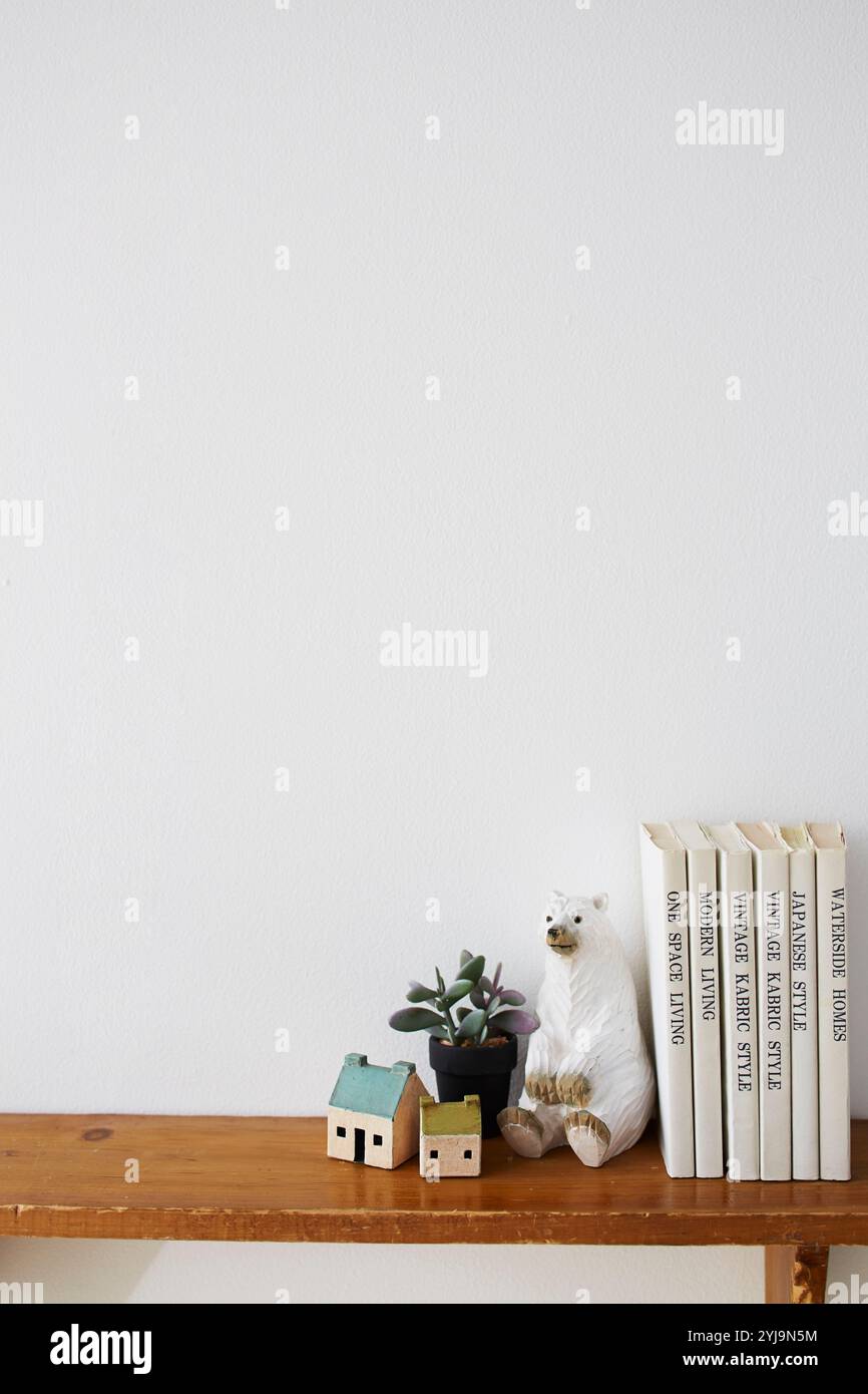 Brown shelf with sundry items and books attached to white wall Stock ...