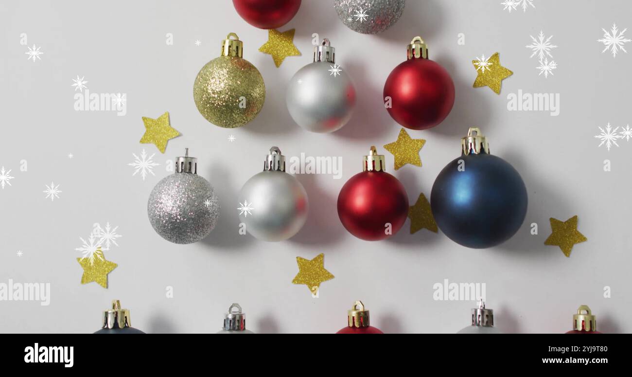 Image of snow falling over christmas baubles and stars. Christmas and ...