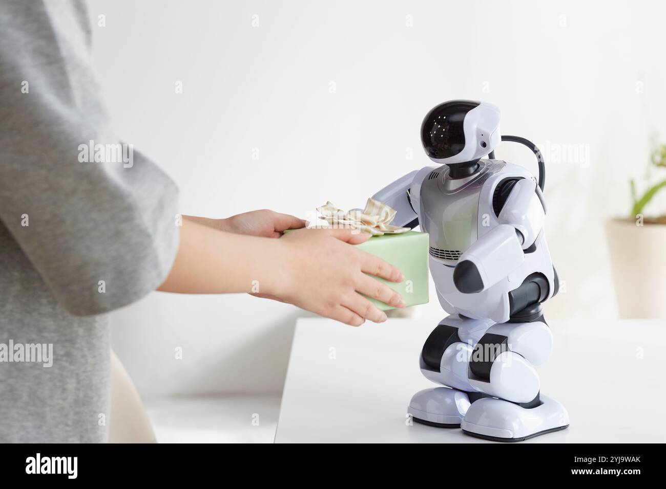 Robot receiving a gift from a woman Stock Photo - Alamy