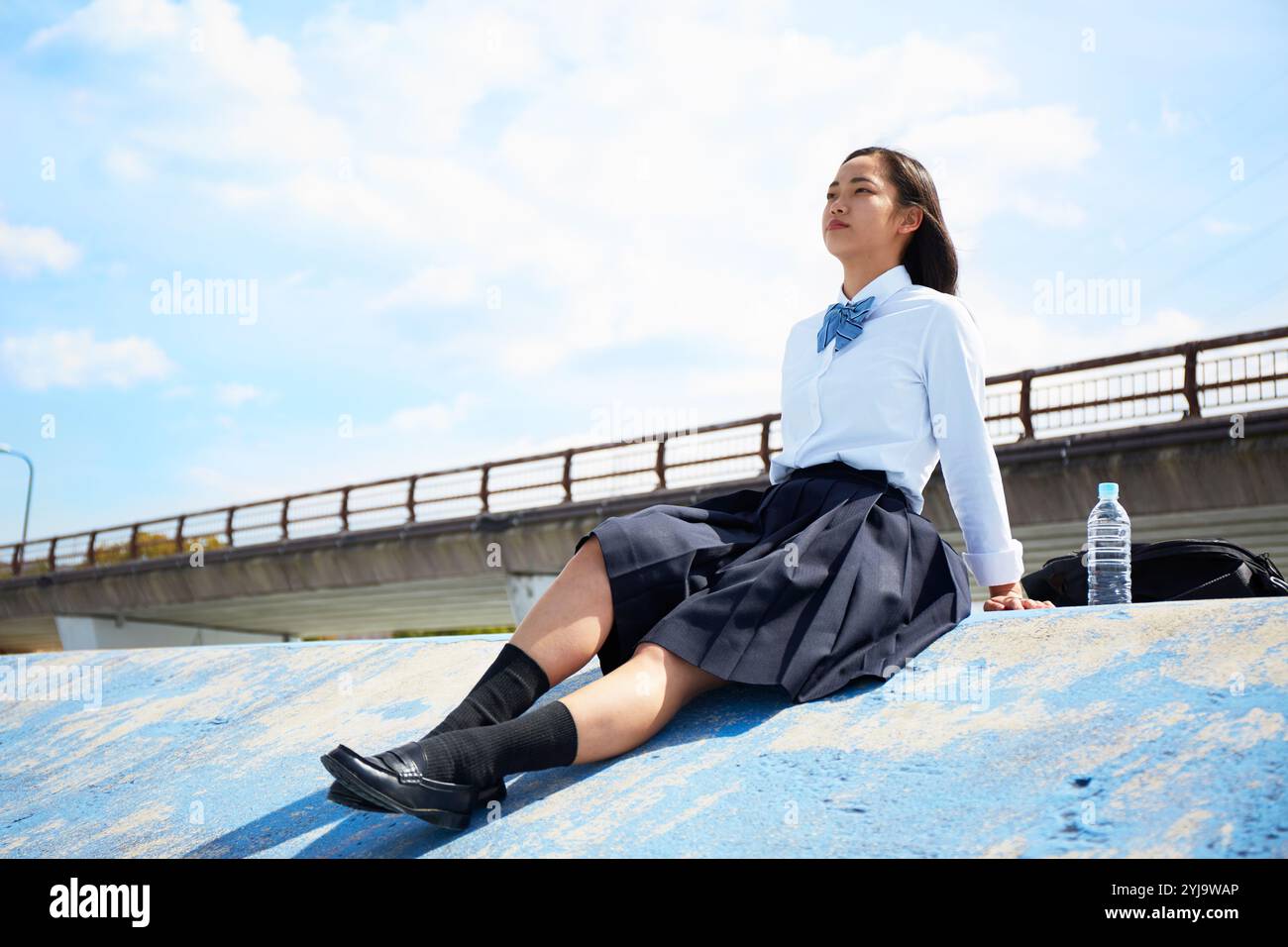 High school girl sitting with legs stretched out on the bank Stock ...