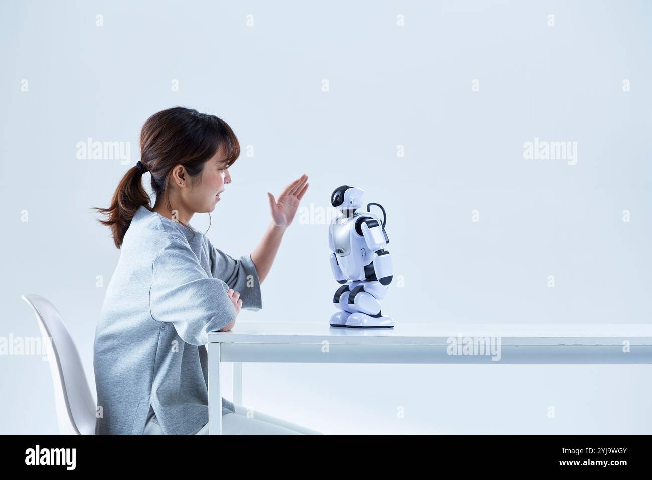 Woman chatting with mini robot Stock Photo - Alamy