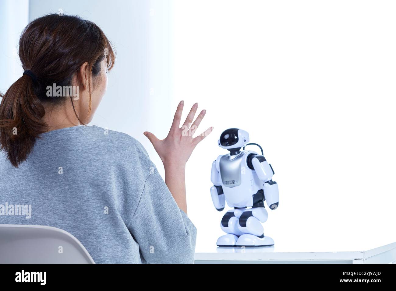 Woman chatting with mini robot Stock Photo - Alamy