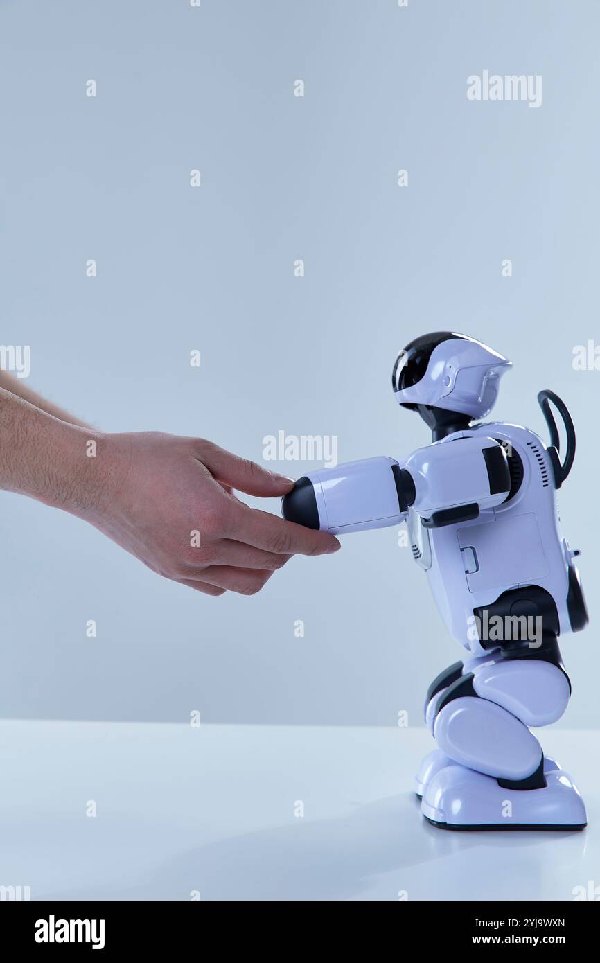 Human hand shaking hands with robot Stock Photo - Alamy