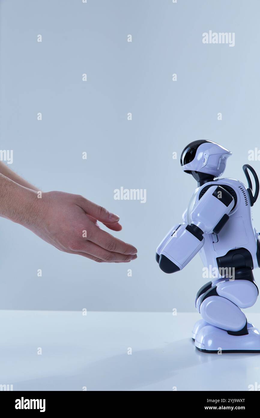 Human hand shaking hands with robot Stock Photo - Alamy