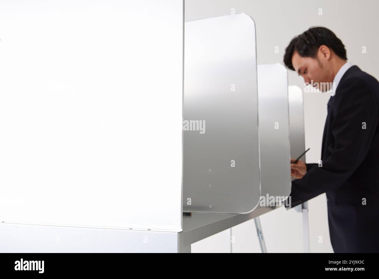 Man in suit using voting registration table Stock Photo - Alamy
