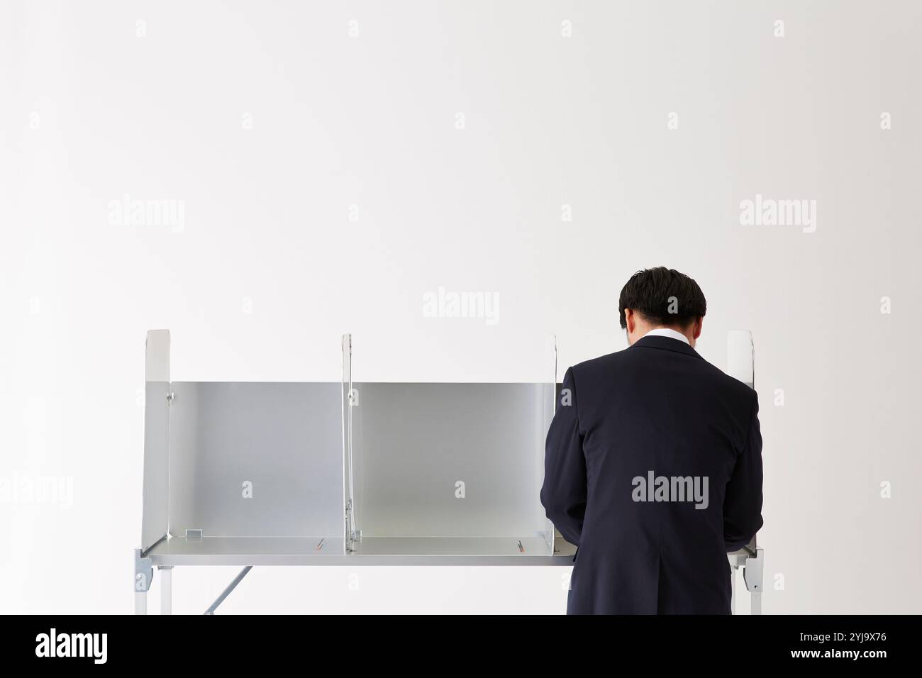 Back view of man in suit using voting registration table Stock Photo ...
