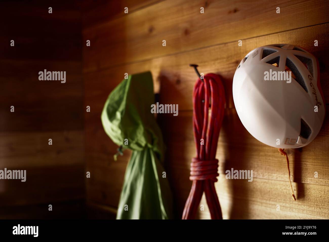 Climbing clothes, ropes and helmets on hooks inside the hut Stock Photo ...