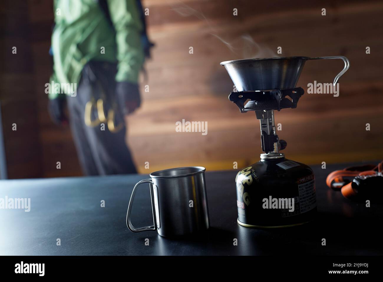 Gas stove on a desk in the hut and people preparing to climb a mountain ...