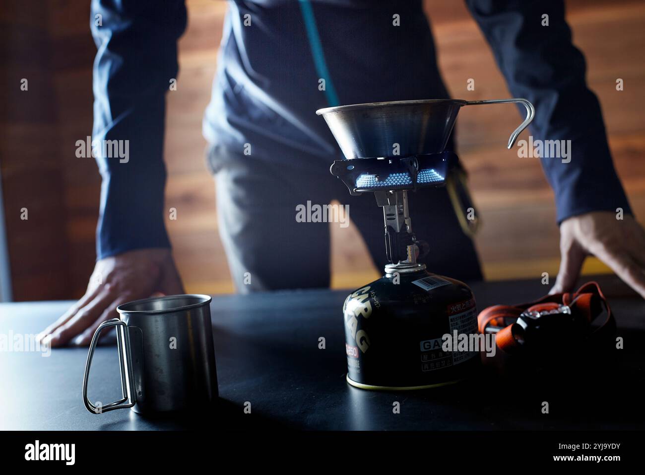 Gas stove on a desk in a mountain hut and a person leaning against the ...