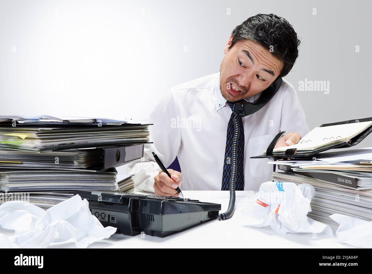 Office worker on the phone at her desk with a pile of work Stock Photo ...