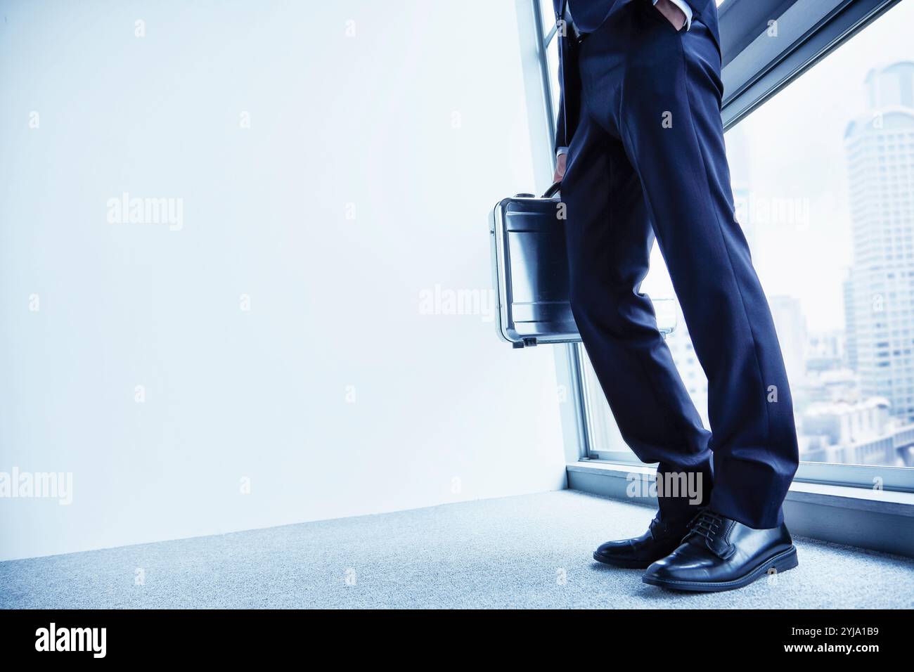 Feet and floor of man standing at window with attache case Stock Photo ...