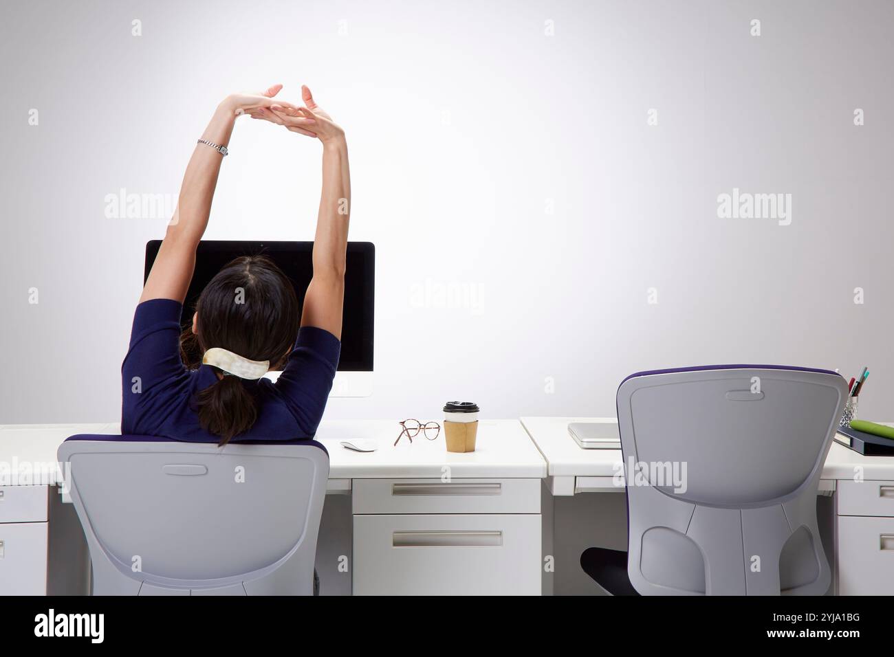 Woman stretching at her desk at work Stock Photo - Alamy