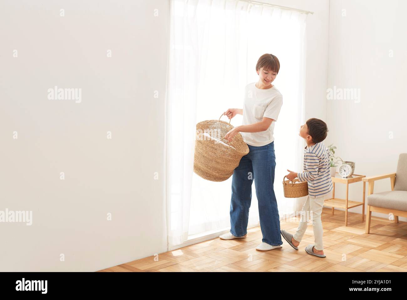 Parents and children carrying baskets of laundry Stock Photo - Alamy