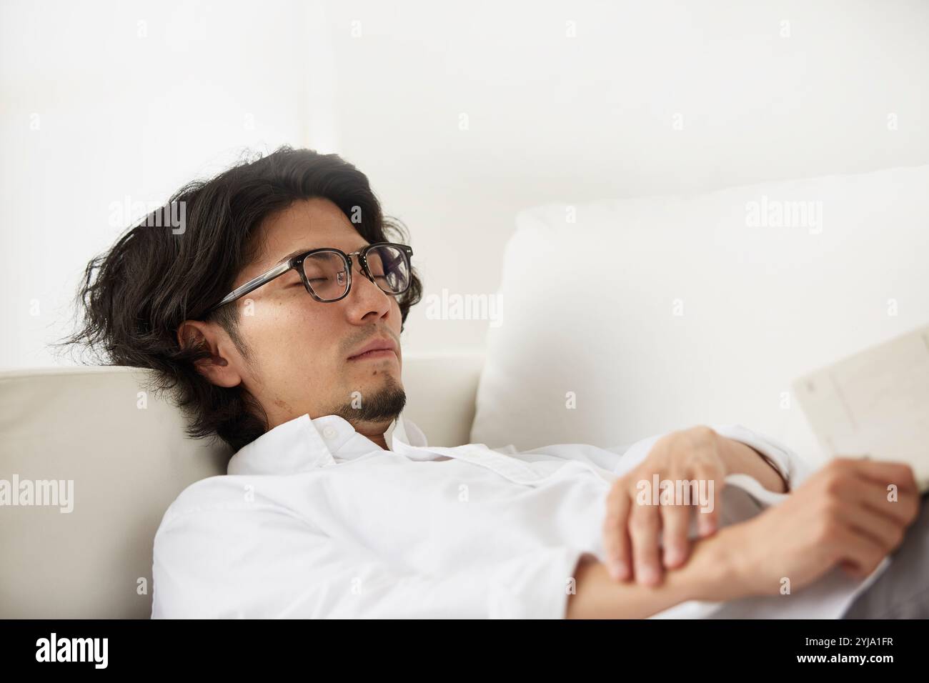 Man lying on sofa Stock Photo - Alamy