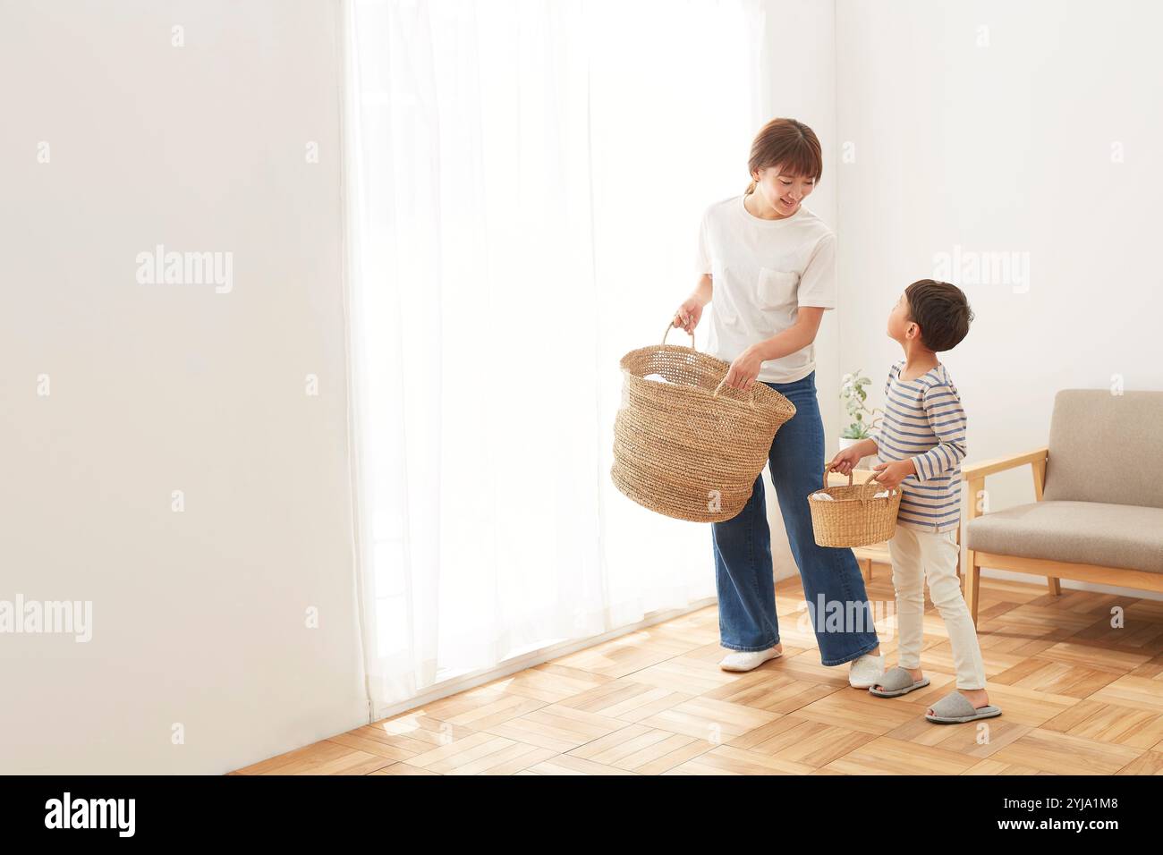 Parents and children carrying baskets of laundry Stock Photo - Alamy