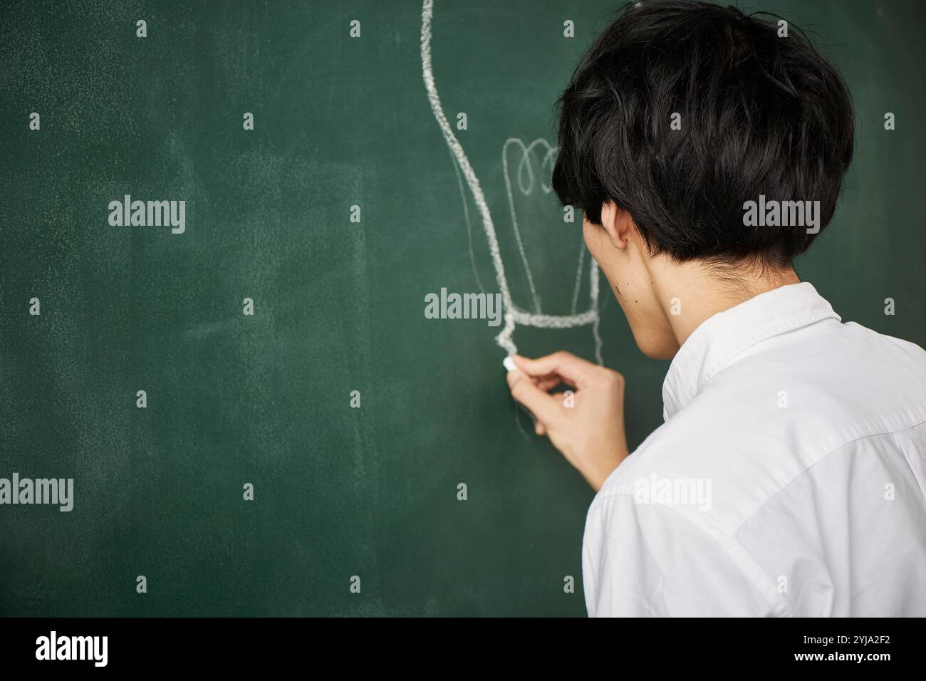 Tracing an illustration of a light bulb on the blackboard Stock Photo ...