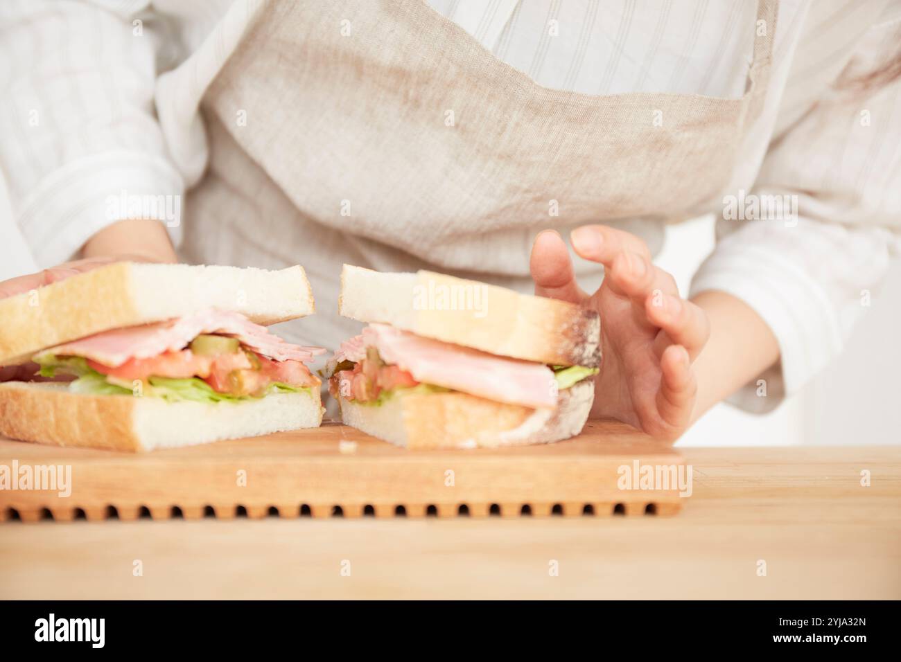 Woman opening a cut-up sandwich Stock Photo - Alamy