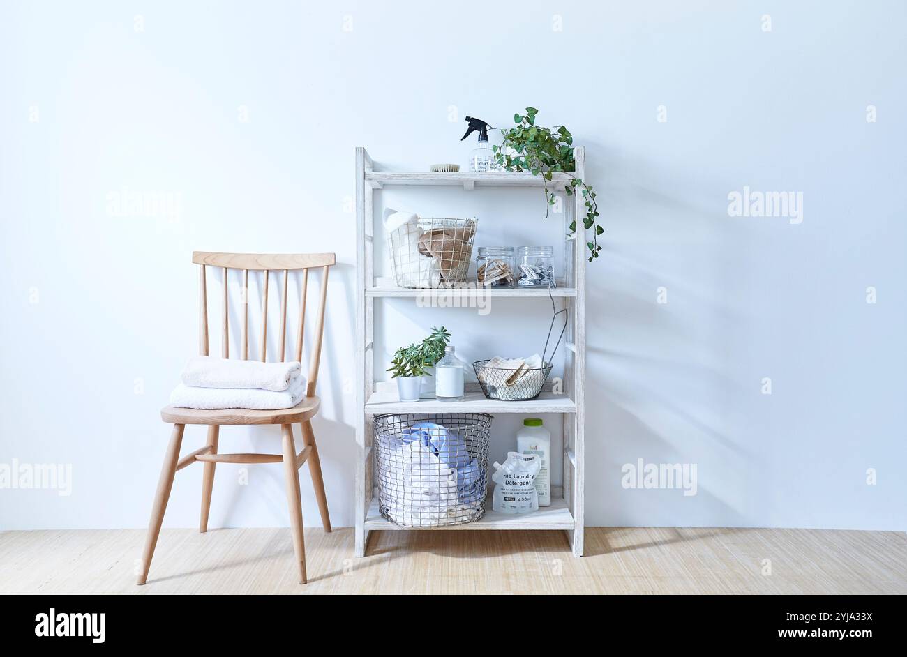 Laundry rack and chair in front of white wall Stock Photo - Alamy
