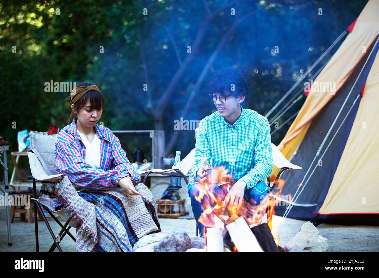 Man and woman around bonfire Stock Photo - Alamy