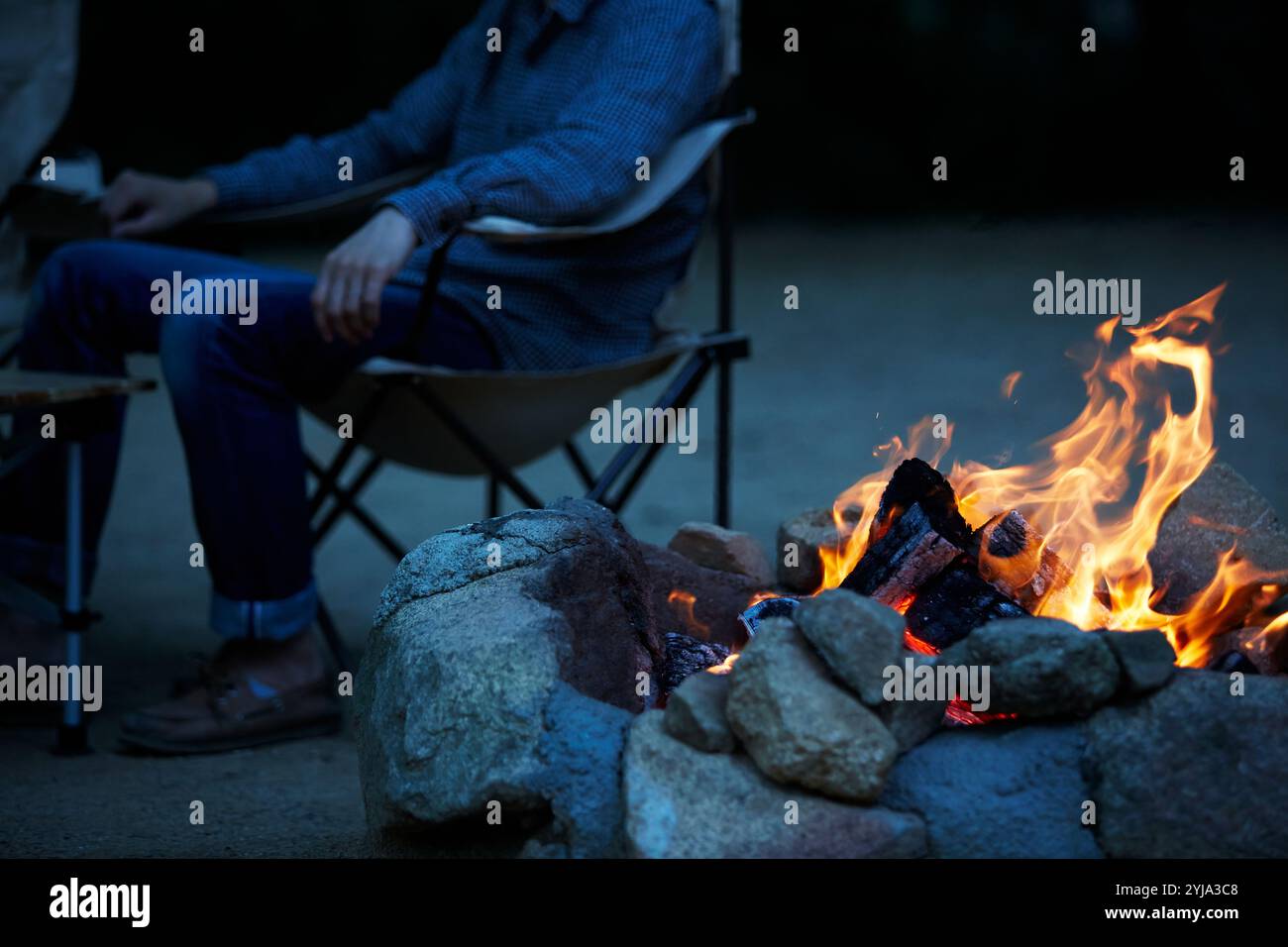 Man warming himself beside the bonfire Stock Photo - Alamy