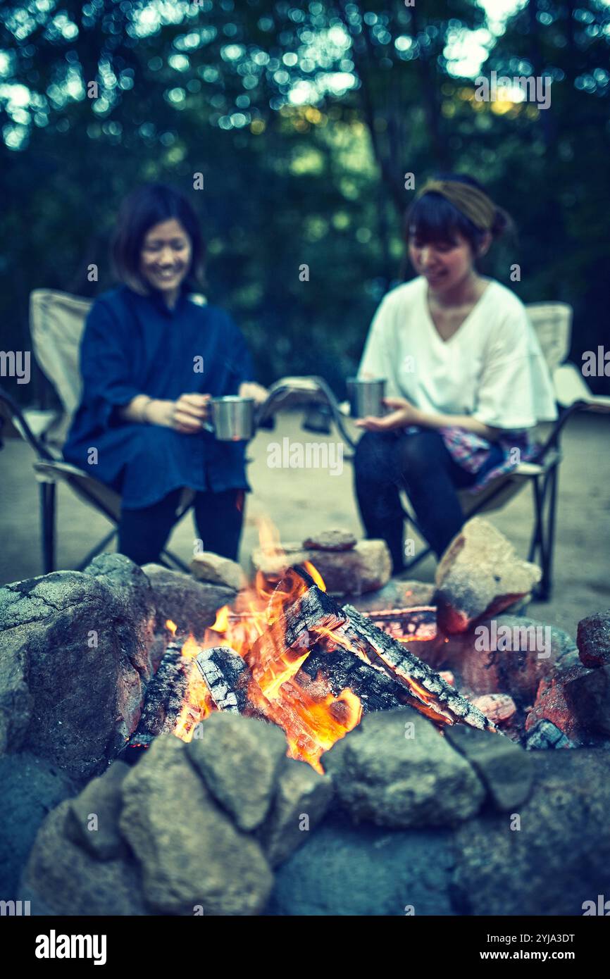 Two people drinking coffee by the bonfire Stock Photo - Alamy