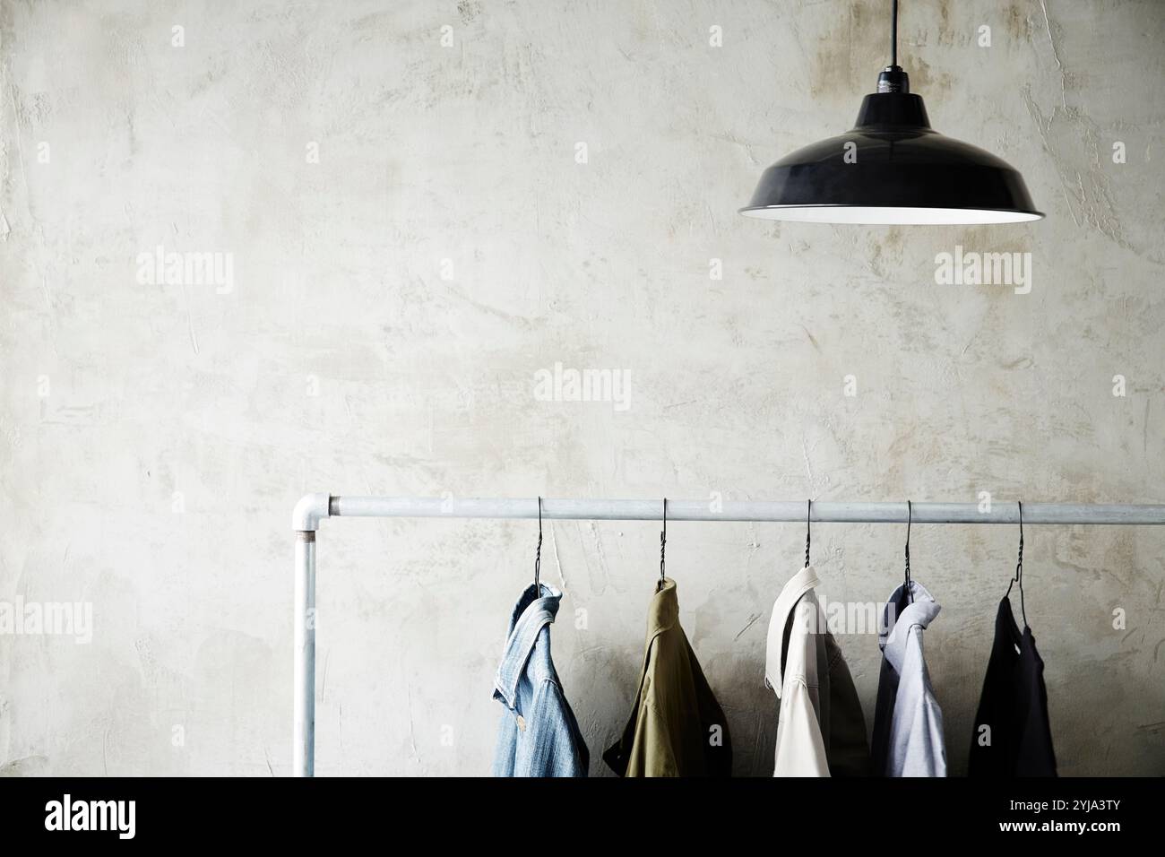 Clothes and light on silver rack Stock Photo - Alamy