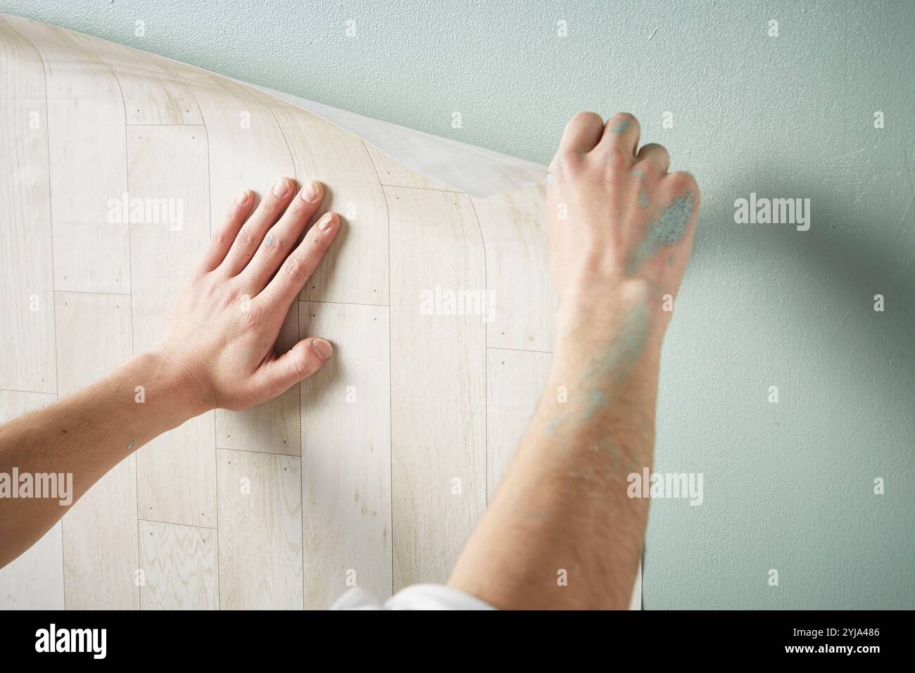Man's hand applying wallpaper Stock Photo - Alamy