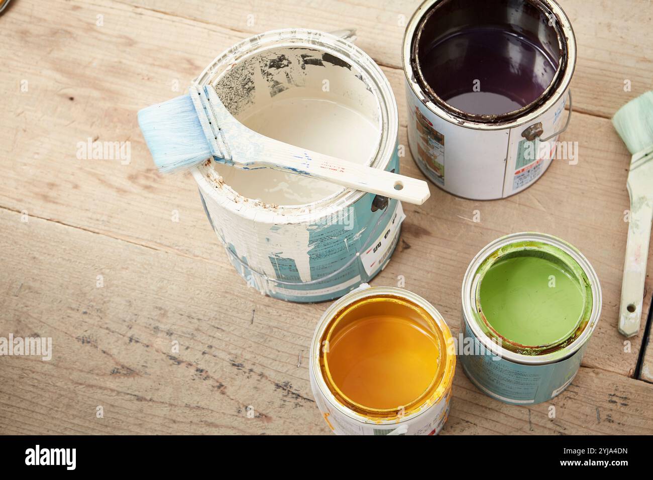4 coloured paint cans and brushes Stock Photo - Alamy