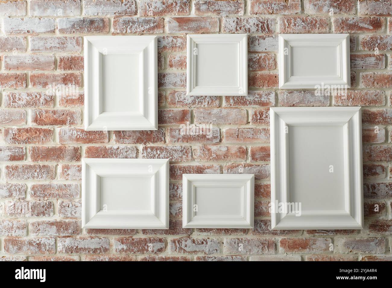 Picture frames hung on brick wall Stock Photo - Alamy