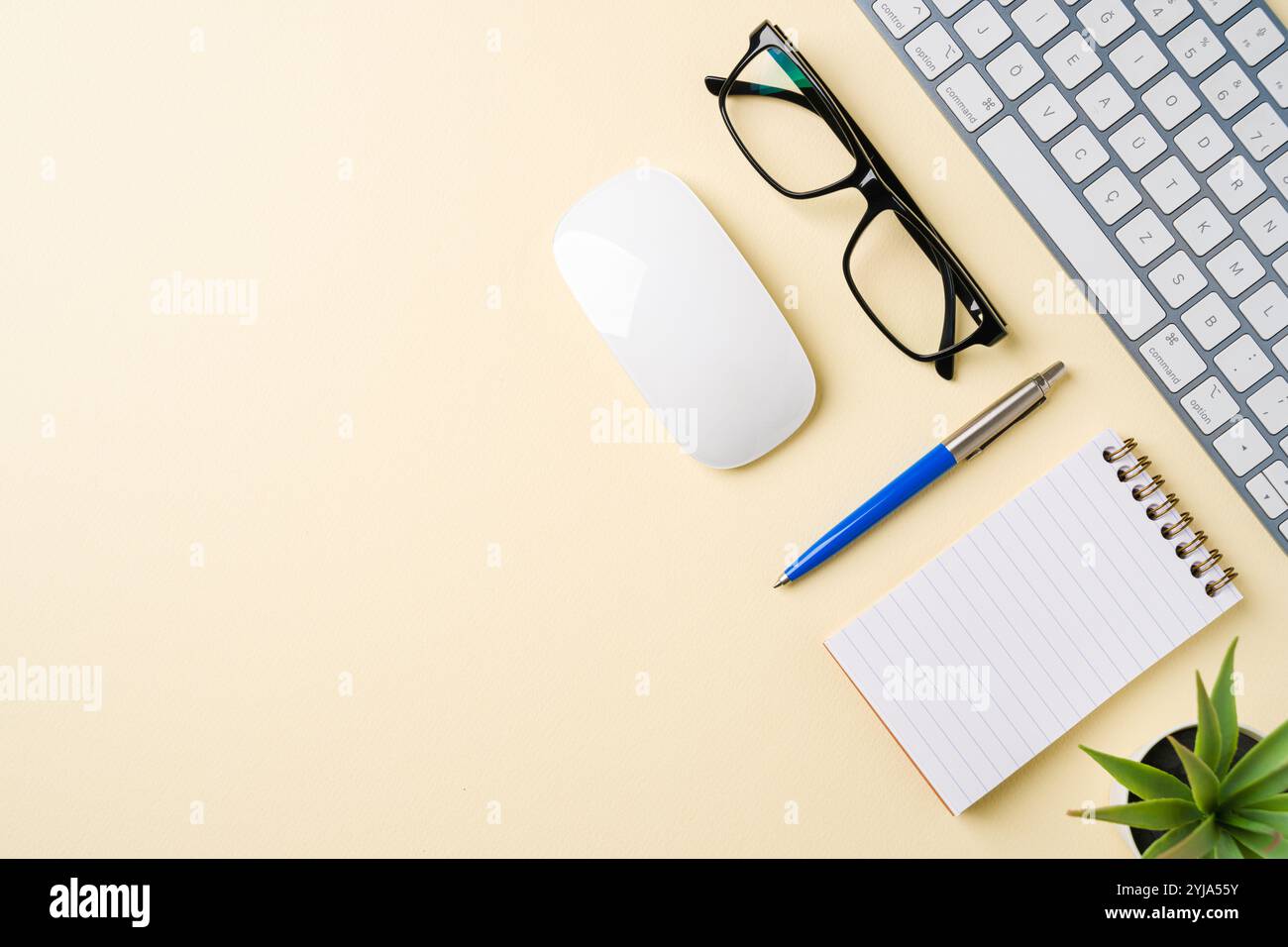 Office desk with computer keyboard, mouse, glasses, notebook and pen ...