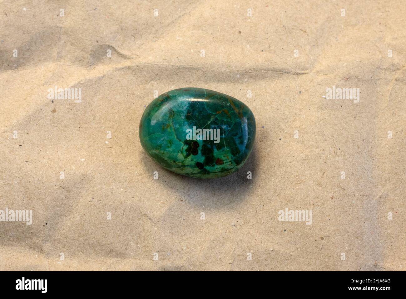 Natural chrysocolla gemstone on craft paper textured background close ...