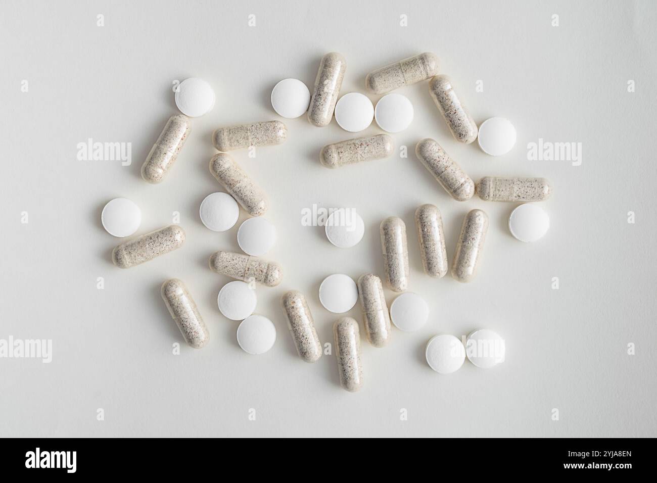 Assorted pills and vitamin capsules on plain background, symbolizing ...