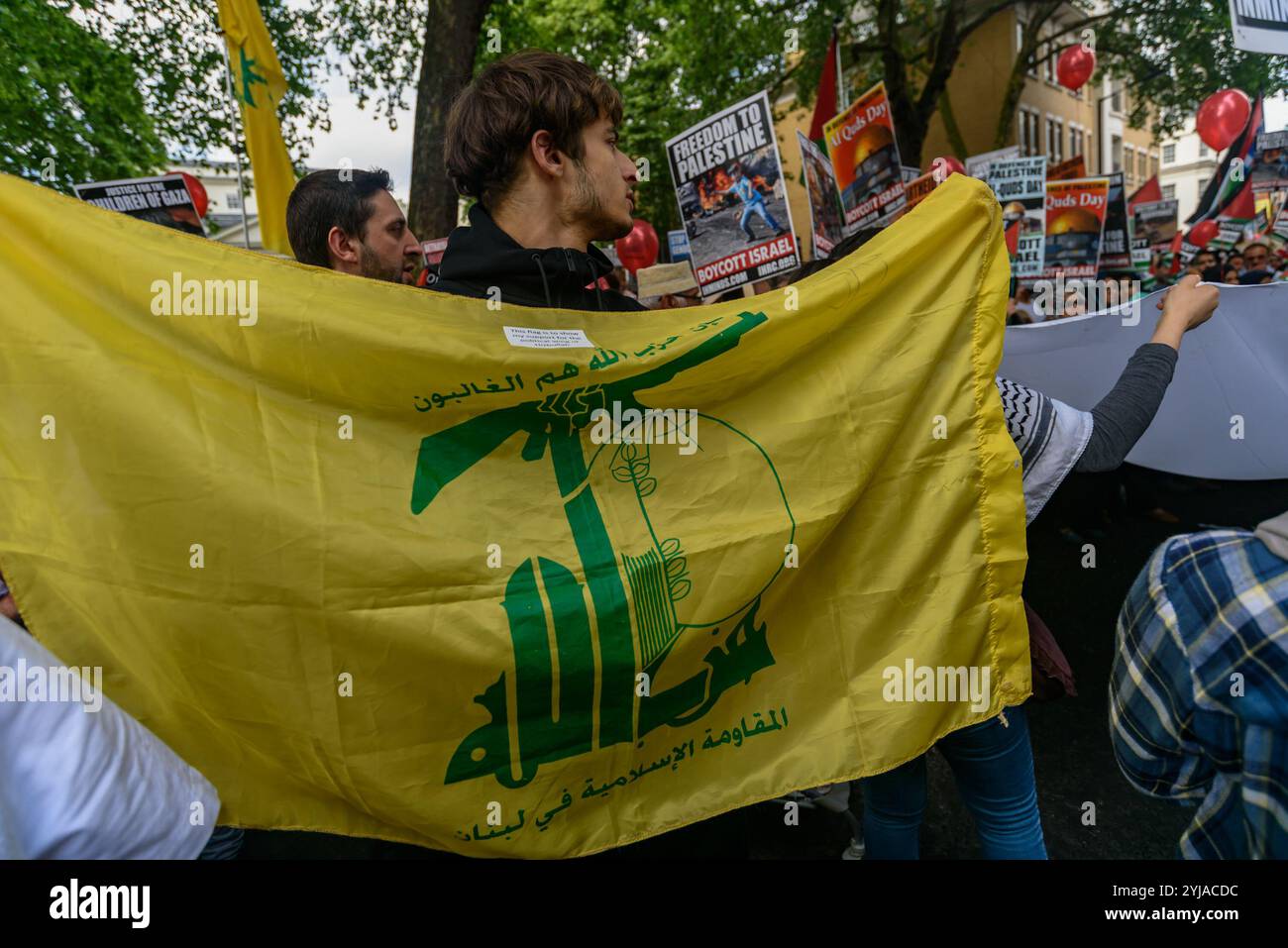 London, UK. 10th June 2018. A man holds a Hizbullah flag in the crowd ...