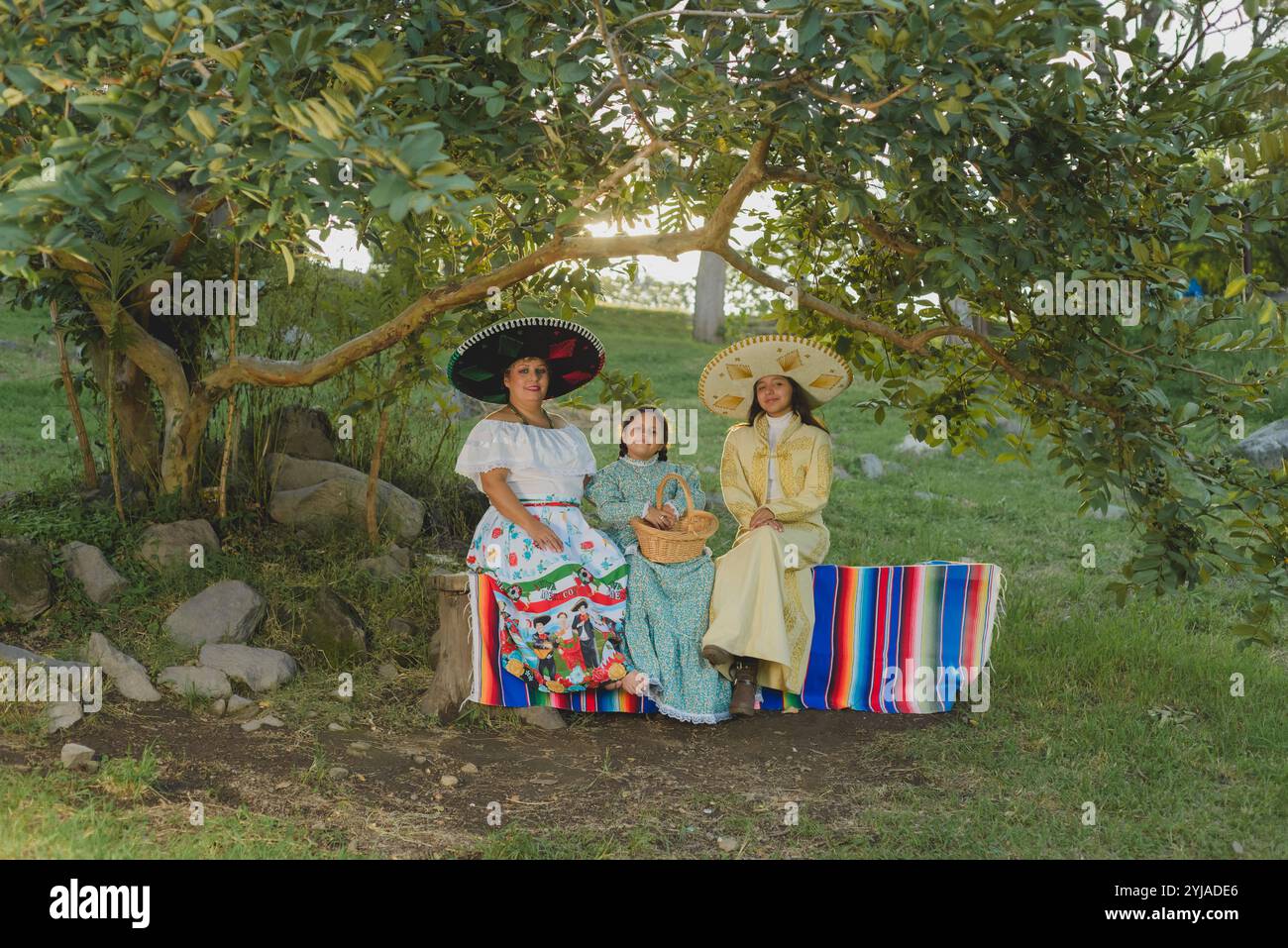 Mother with her daughters wearing typical mexican clothes sitting on ...