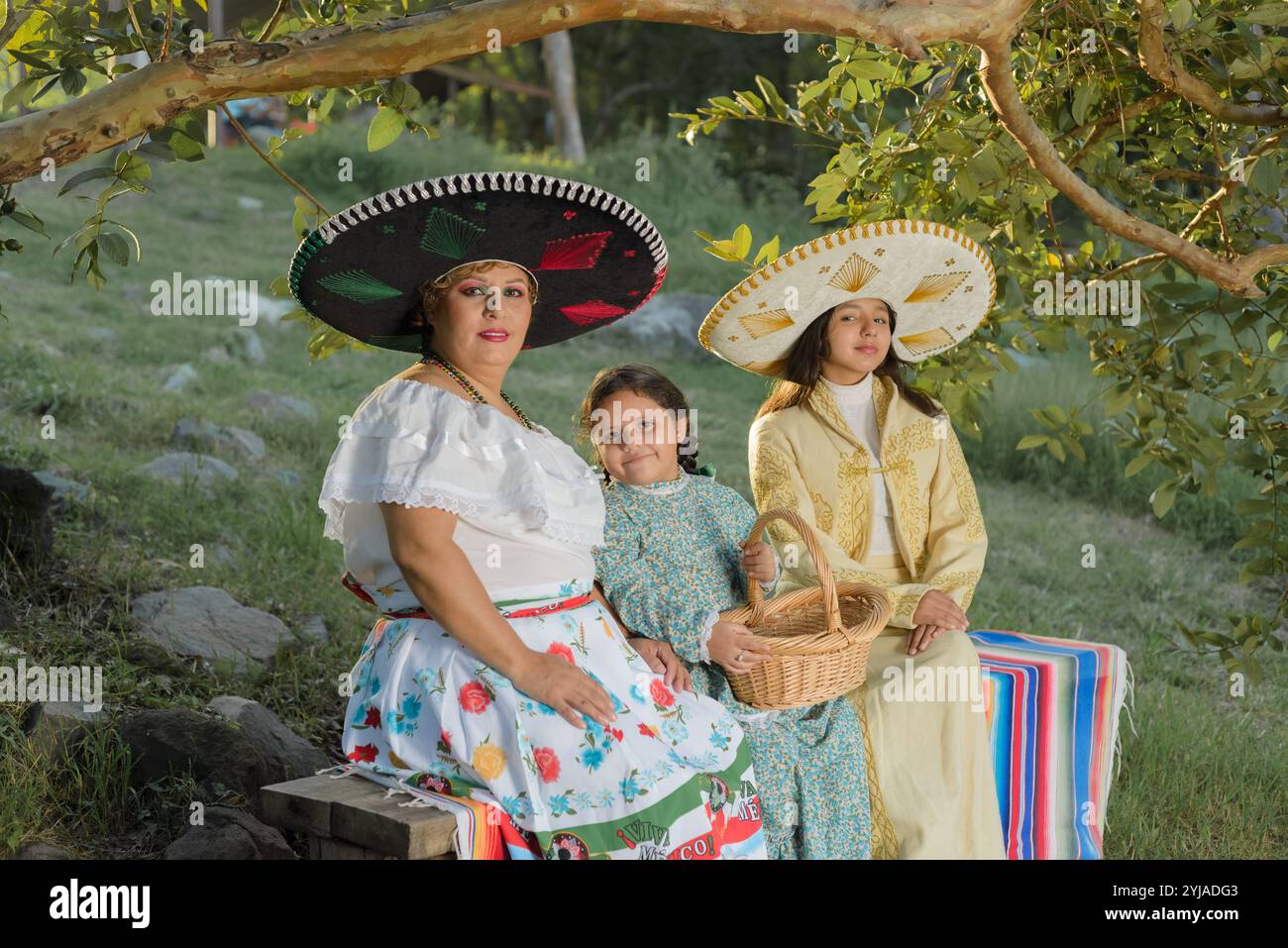 Mother with her daughters wearing typical mexican clothes sitting on ...