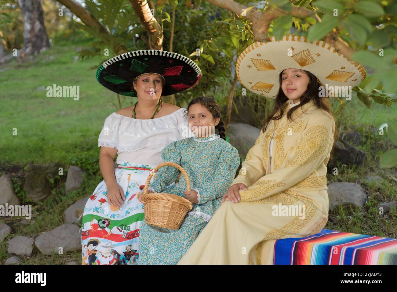Mother with her daughters wearing typical mexican clothes sitting on ...