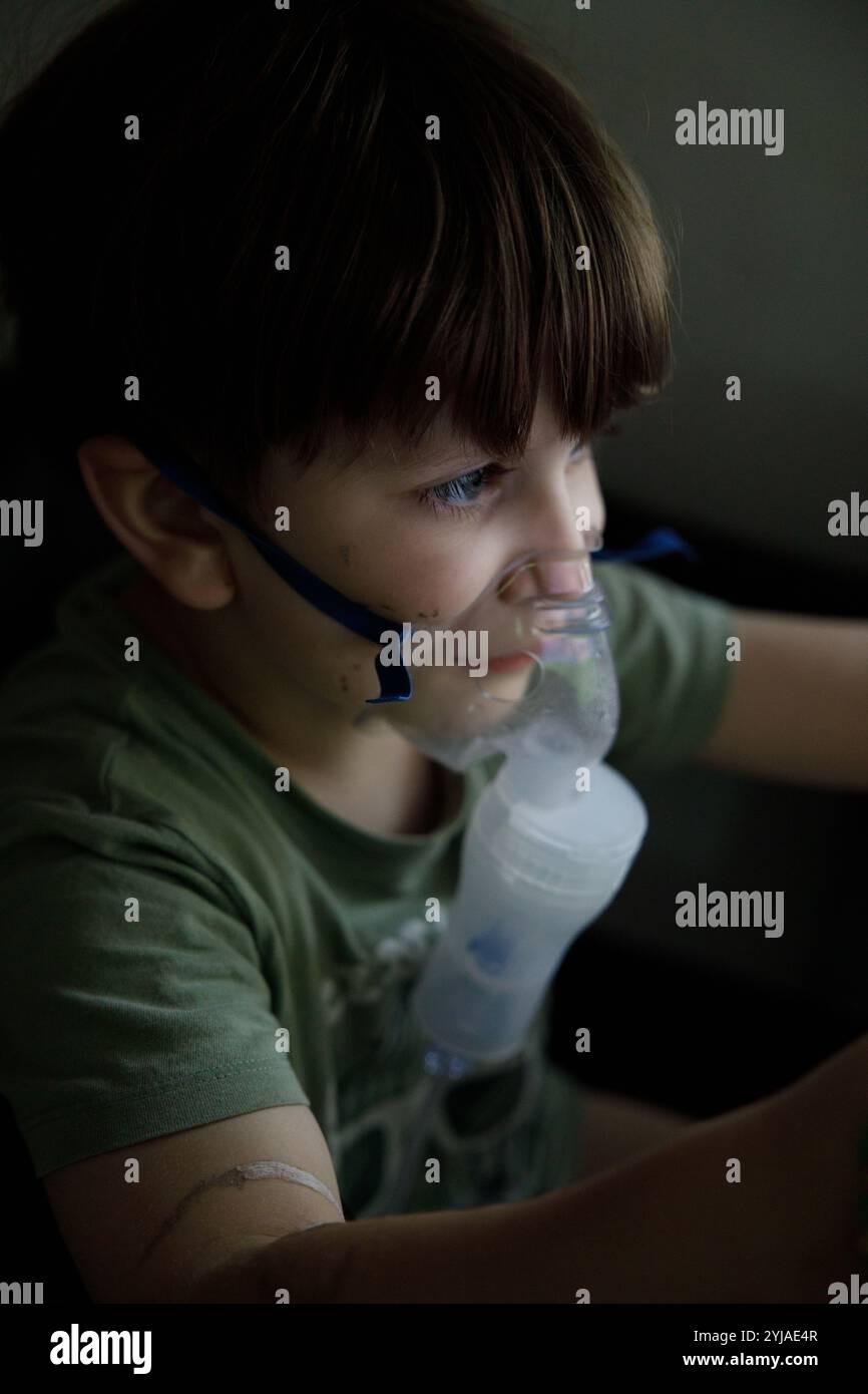 A young child using a nebulizer mask for asthma and respiratory ...