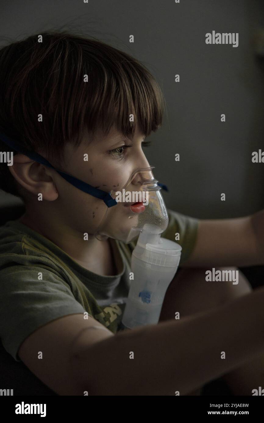 A young child using a nebulizer mask for asthma and respiratory ...
